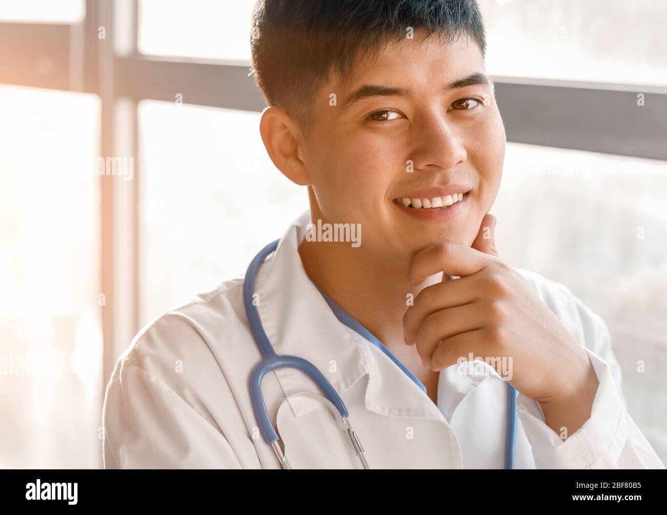 Male Asian doctor near window in clinic Stock Photo - Alamy