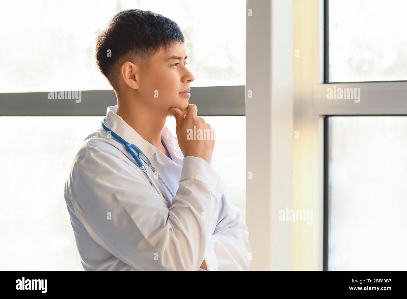 Male Asian doctor near window in clinic Stock Photo - Alamy