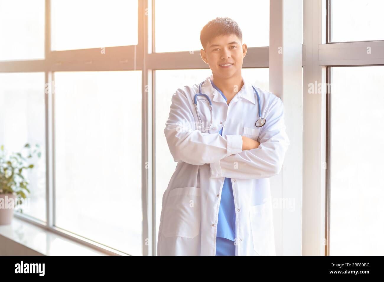 Male Asian doctor near window in clinic Stock Photo - Alamy