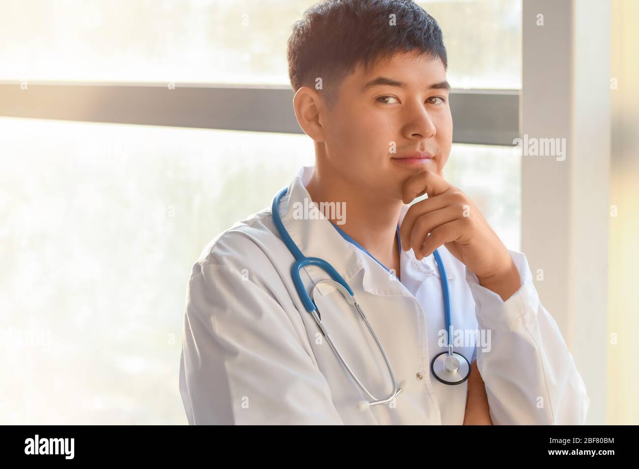 Male Asian doctor near window in clinic Stock Photo - Alamy