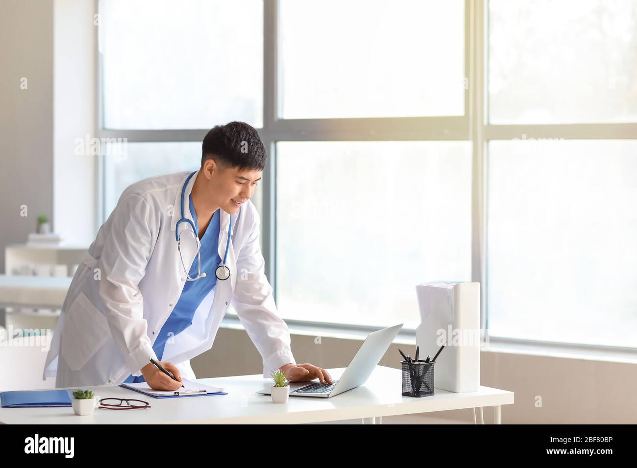 Male Asian doctor working in clinic Stock Photo - Alamy