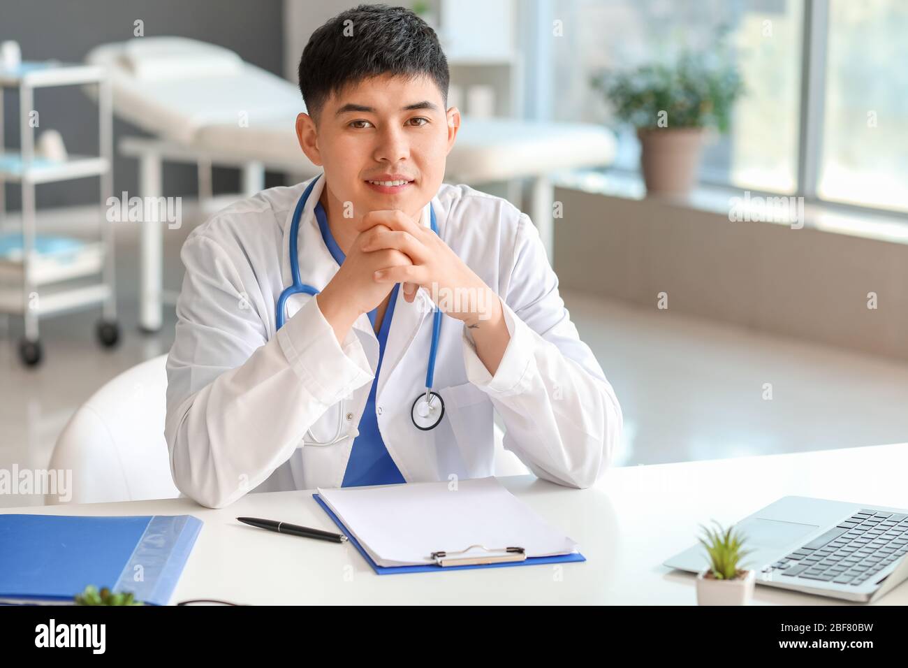 Male Asian doctor working in clinic Stock Photo - Alamy