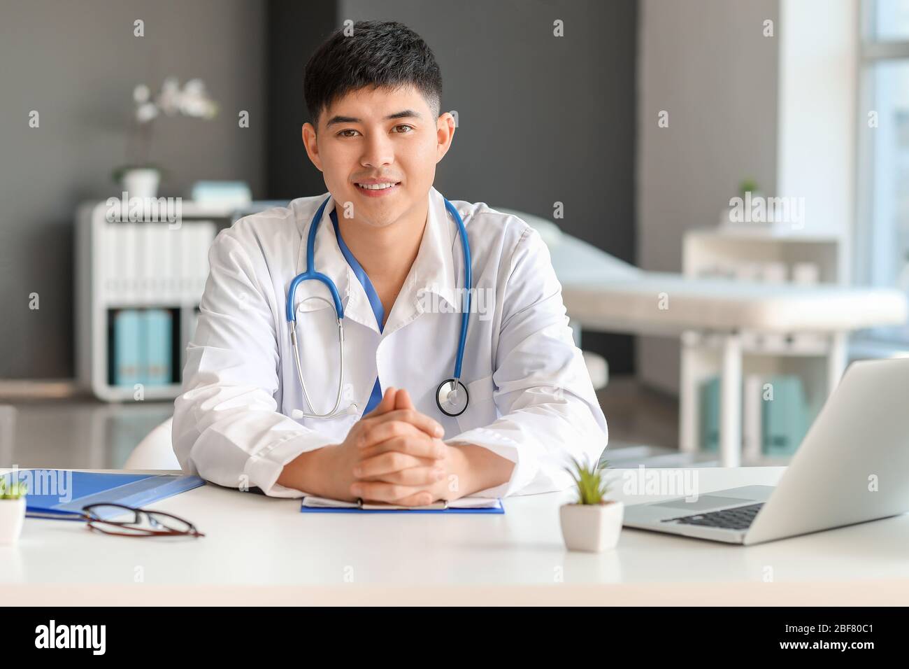 Male Asian doctor working in clinic Stock Photo - Alamy
