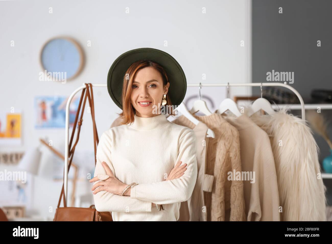 Female stylist near rack with modern clothes in her studio Stock Photo ...