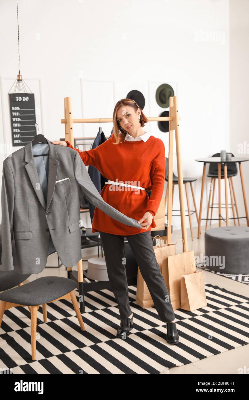 Female stylist with male clothes in her studio Stock Photo - Alamy