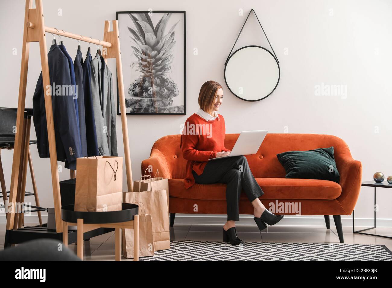 Female stylist with laptop in her studio Stock Photo - Alamy