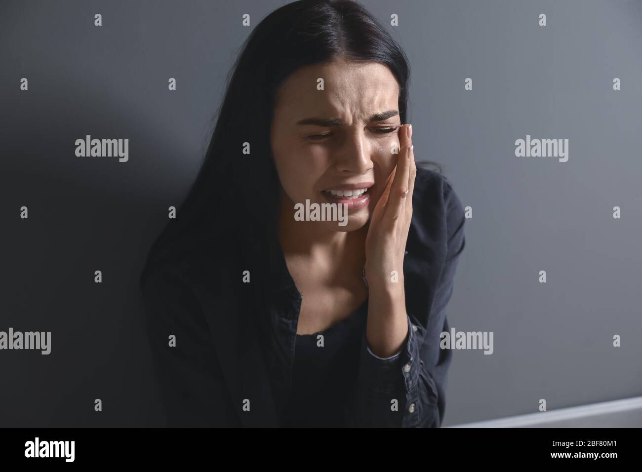 Scared female victim on grey background. Concept of violence Stock ...