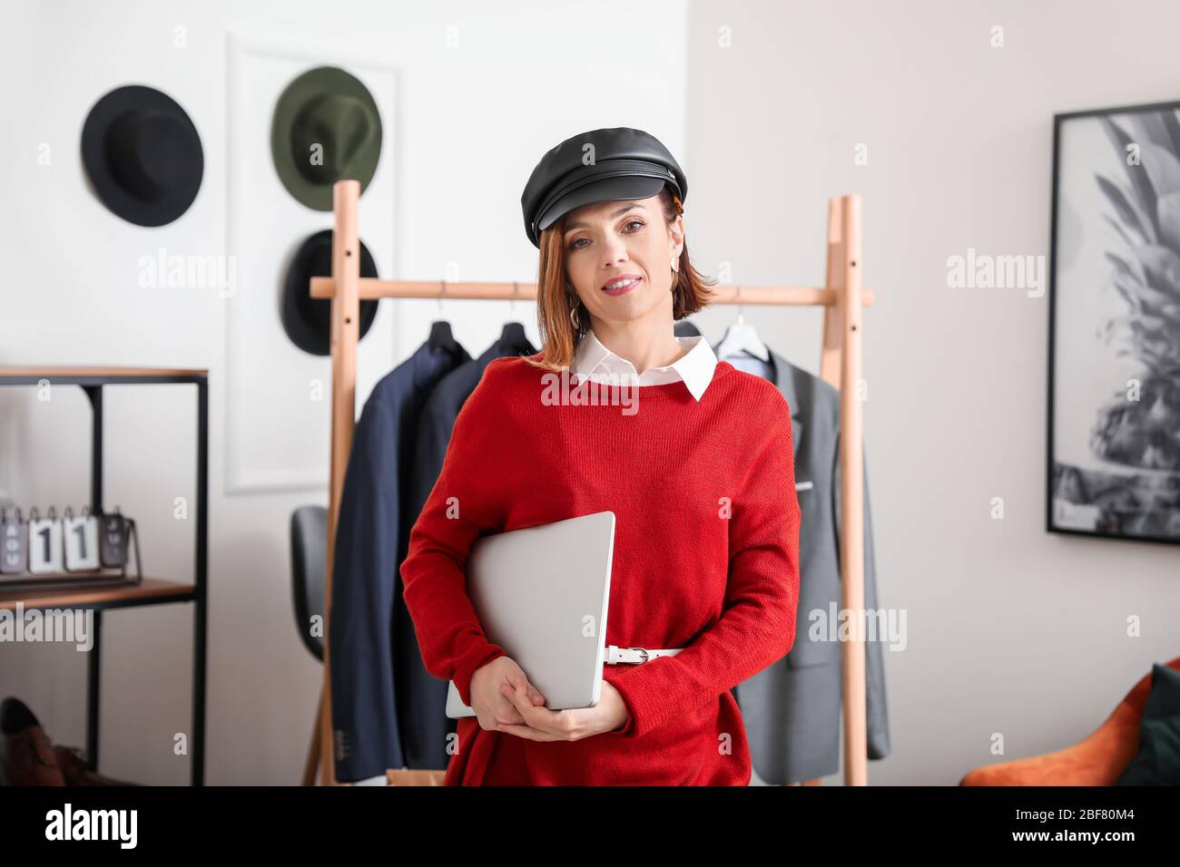 Female stylist with laptop in her studio Stock Photo - Alamy