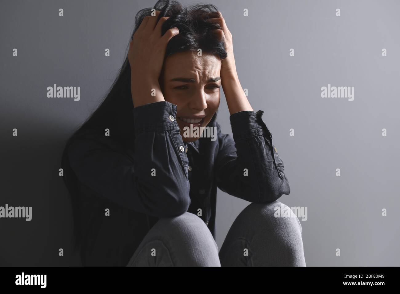 Scared female victim on grey background. Concept of violence Stock ...