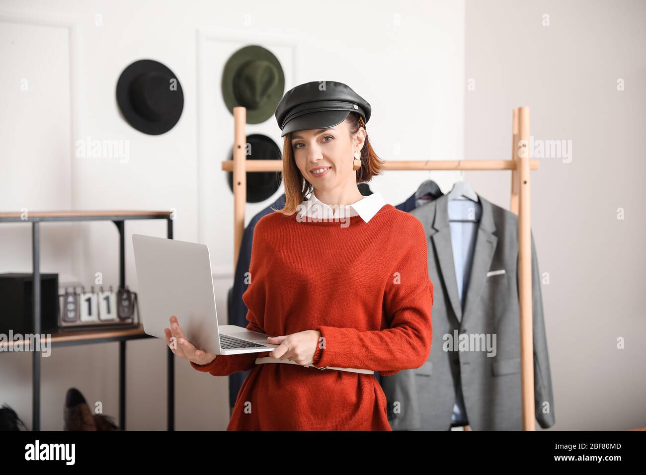 Female stylist with laptop in her studio Stock Photo - Alamy