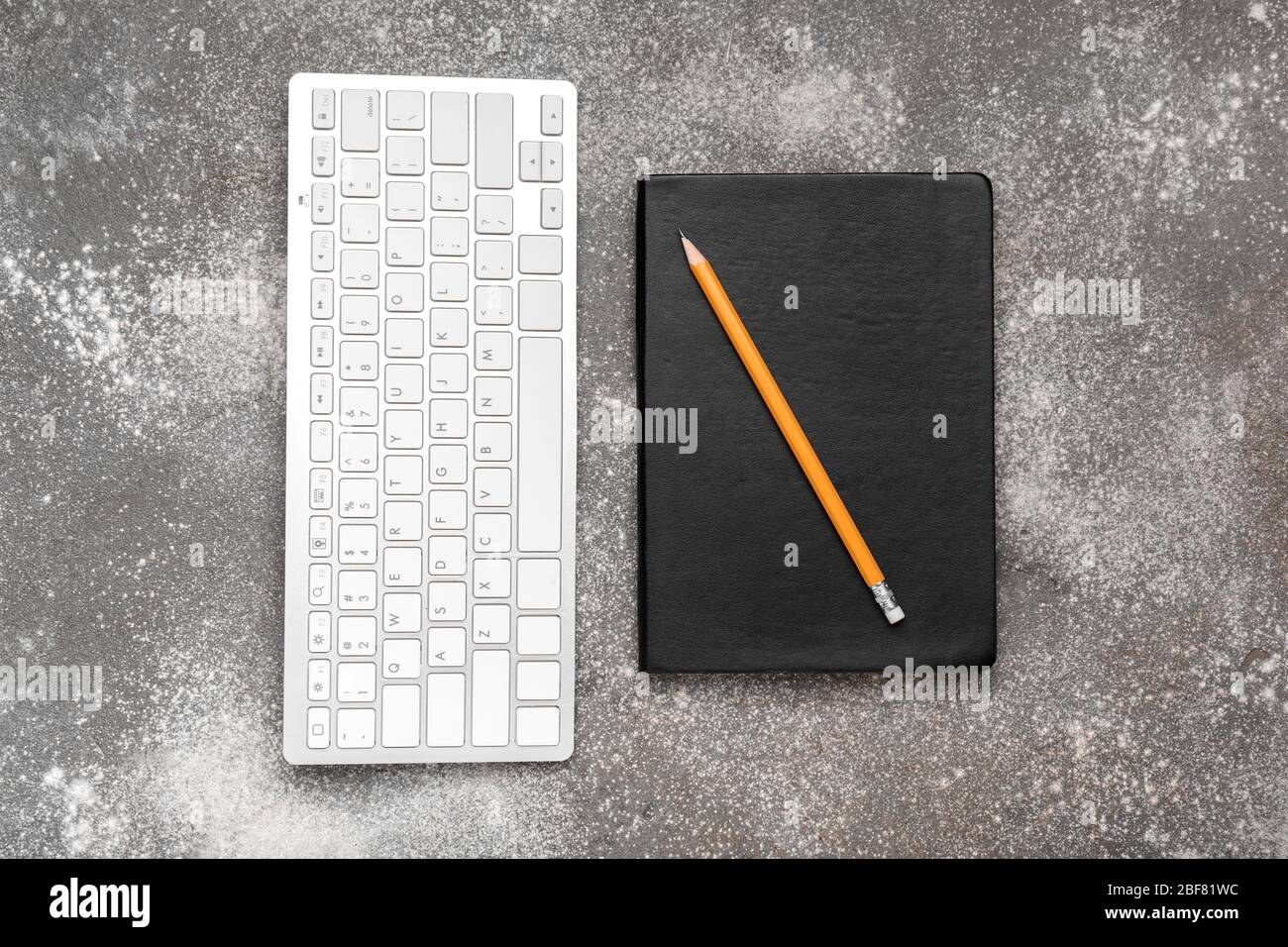 Notebook, ordinary pencil and PC keyboard on grey background Stock ...