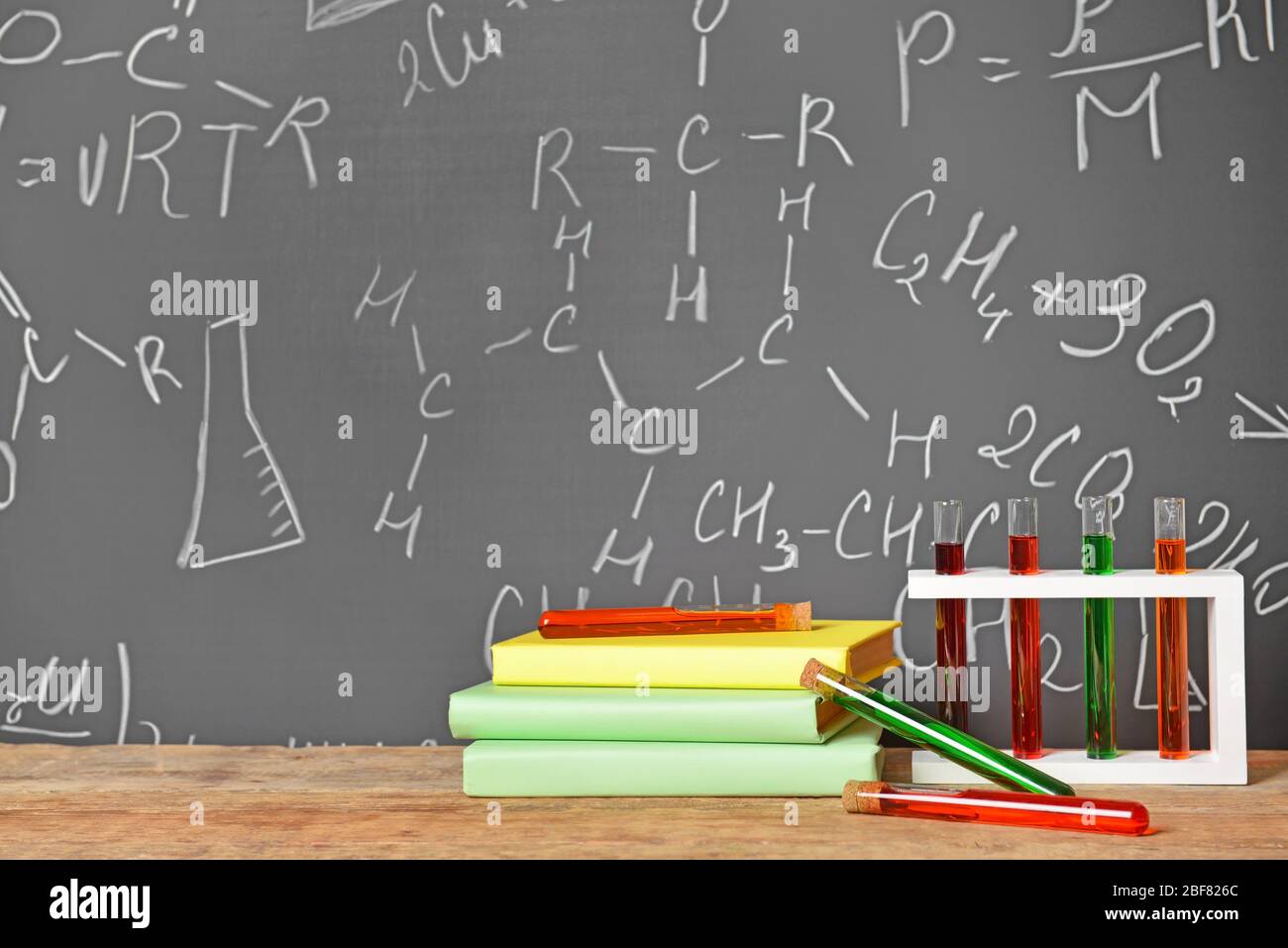School supplies and test tubes on table near blackboard Stock Photo - Alamy