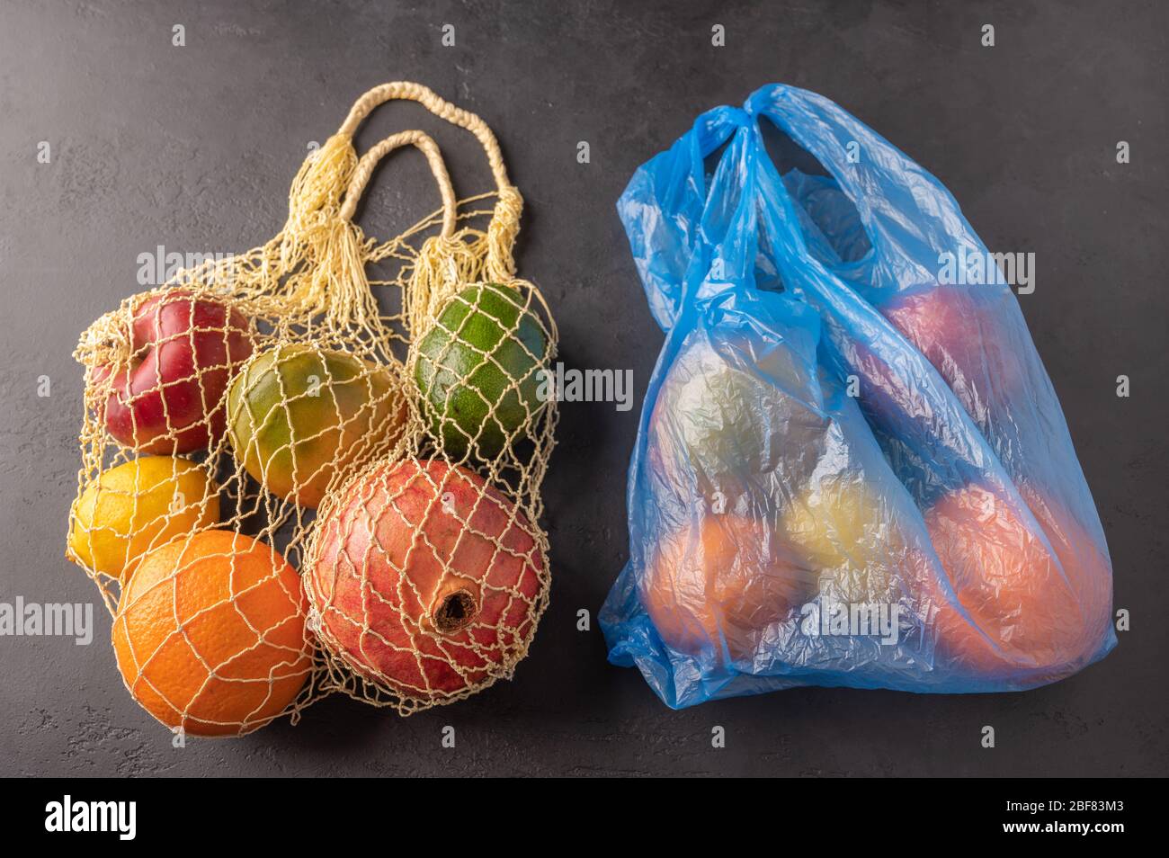 Bunch of mixed organic fruit, vegetables and greens in a string bag and ...