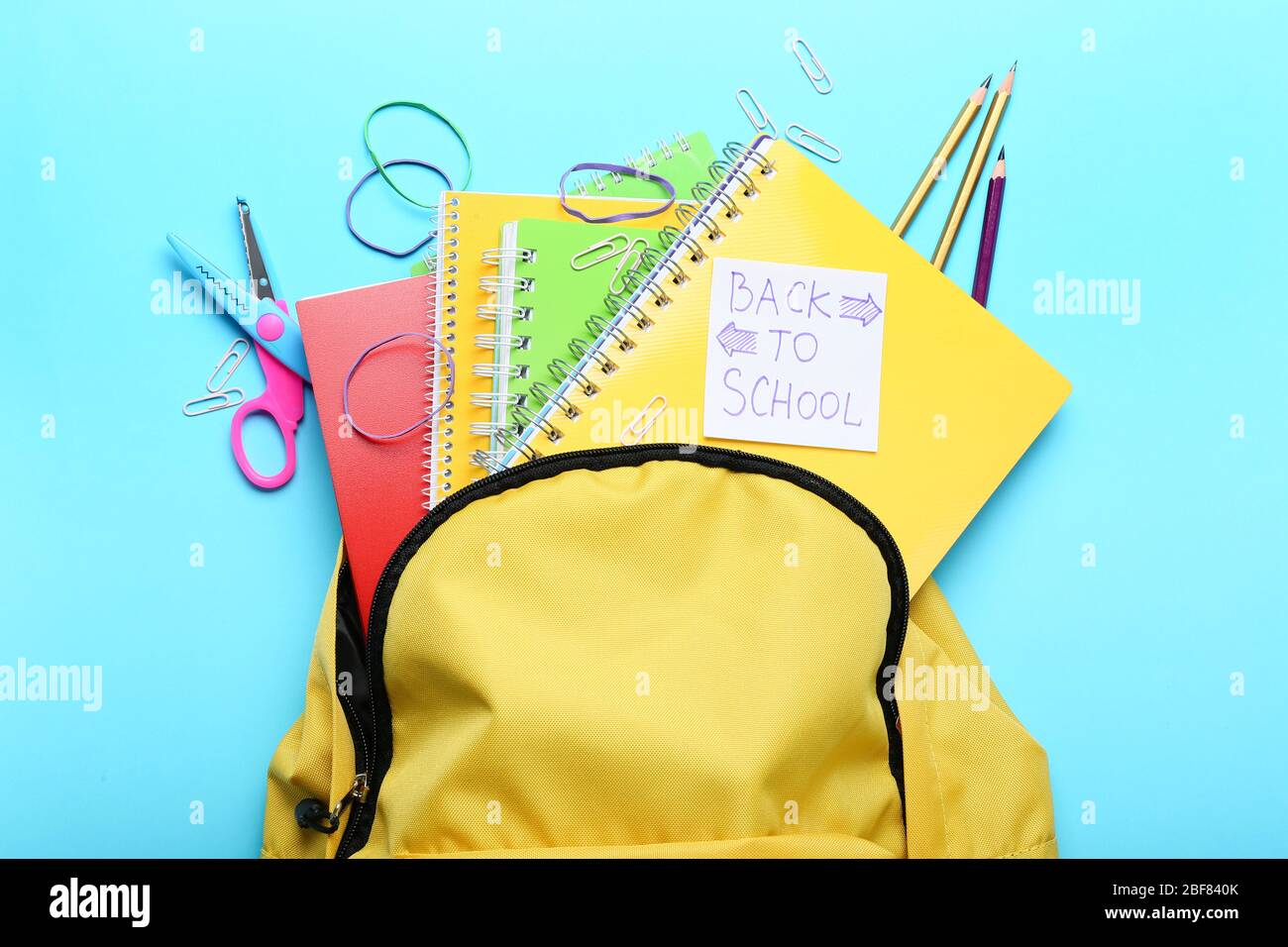 Backpack with school supplies on color background Stock Photo - Alamy