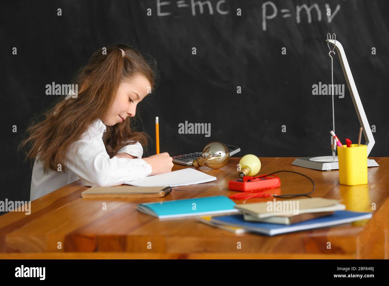 Cute little girl at physics lesson in classroom Stock Photo - Alamy