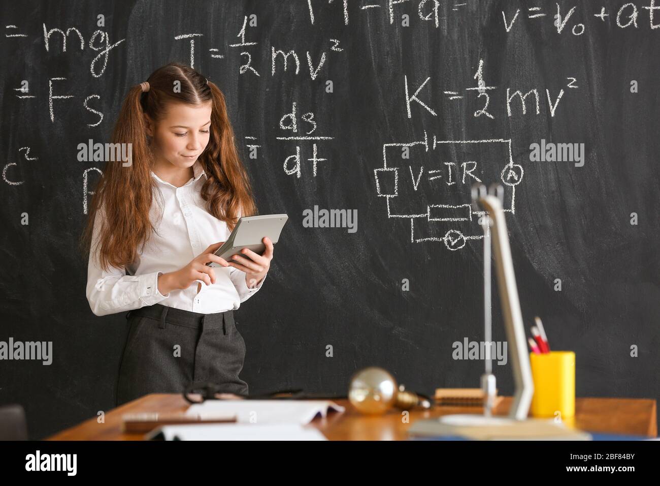 Cute little girl at physics lesson in classroom Stock Photo - Alamy