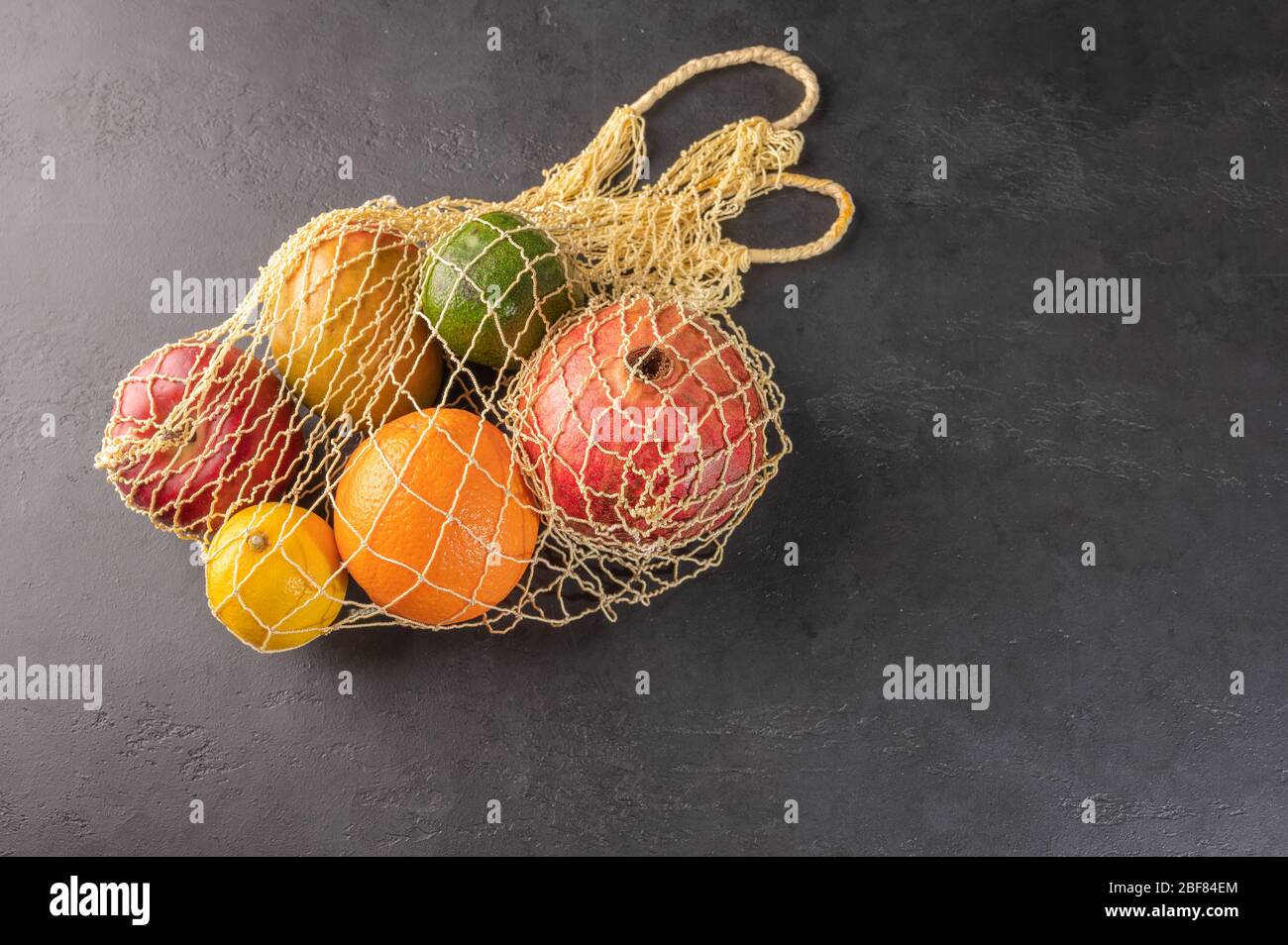 Bunch of mixed organic fruit, vegetables and greens in a string bag on ...