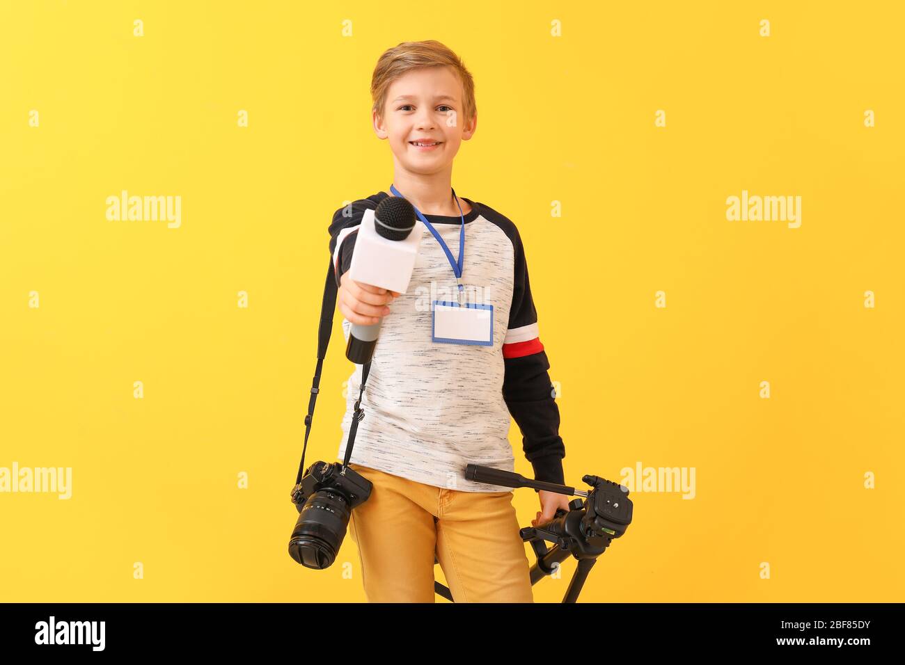 Little journalist with microphone and camera on color background Stock ...