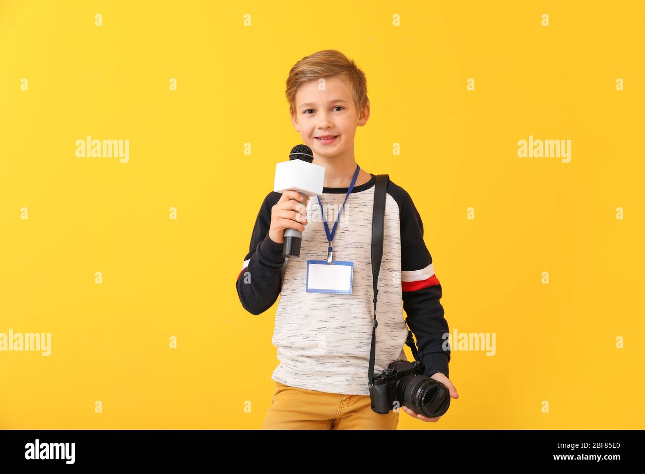 Little journalist with microphone and camera on color background Stock ...