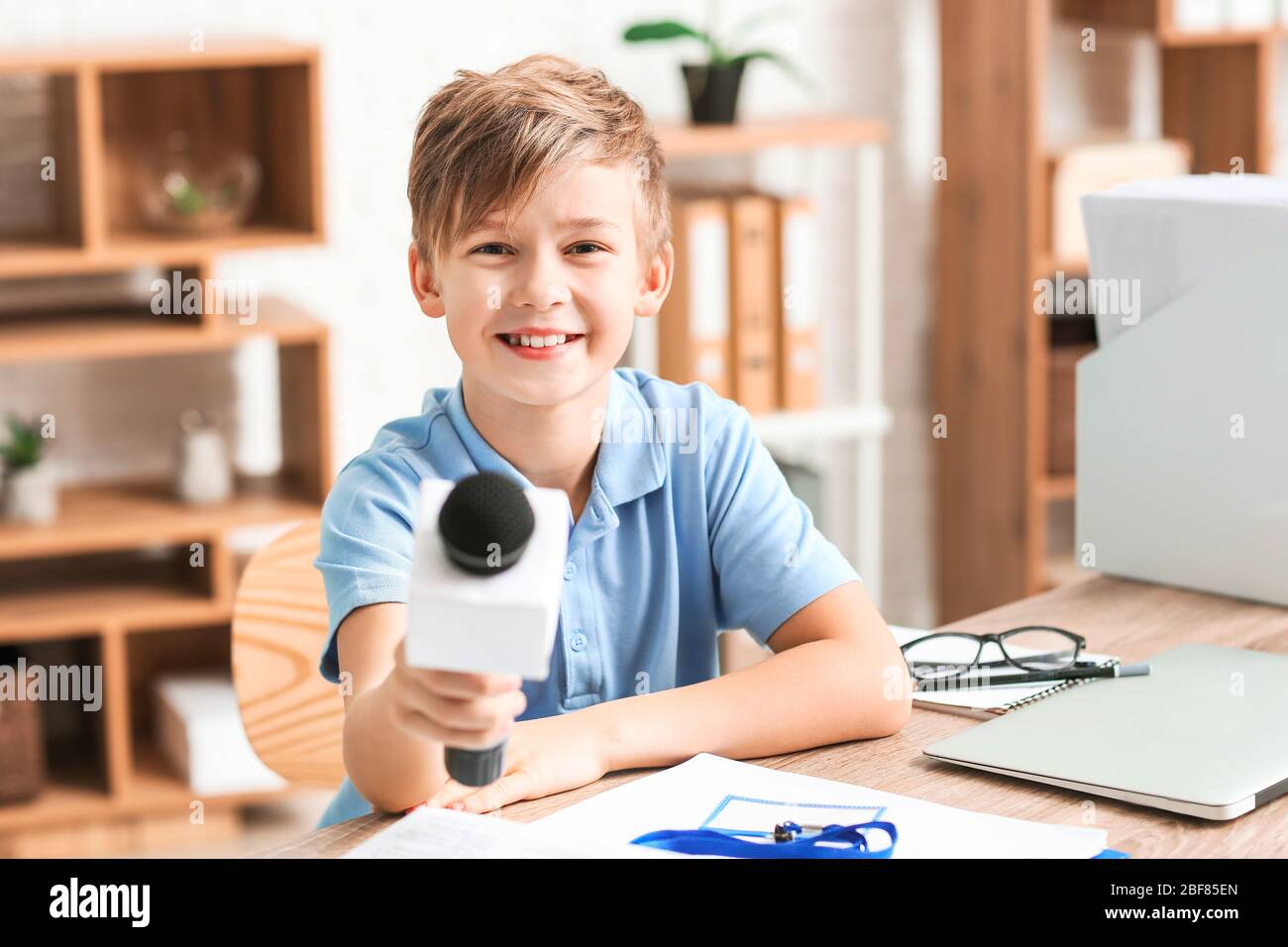 Little journalist with microphone having an interview in office Stock ...