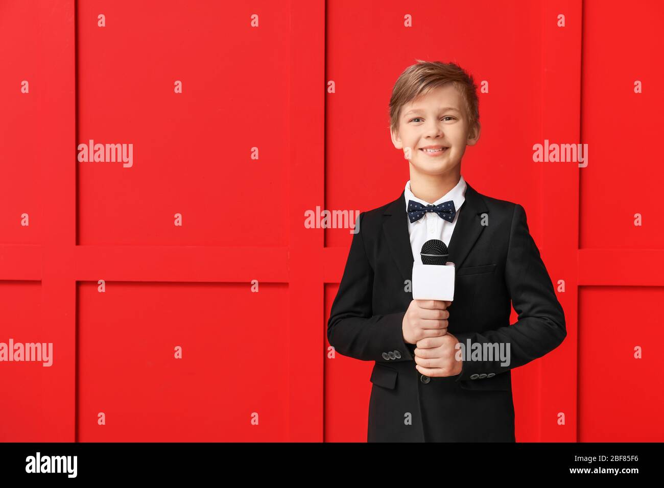 Little journalist with microphone on color background Stock Photo - Alamy