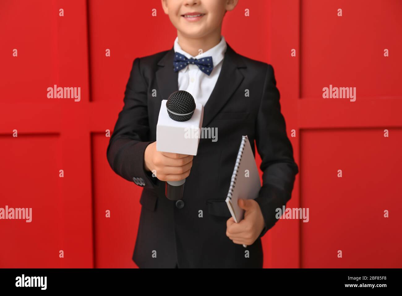 Little journalist with microphone on color background Stock Photo - Alamy