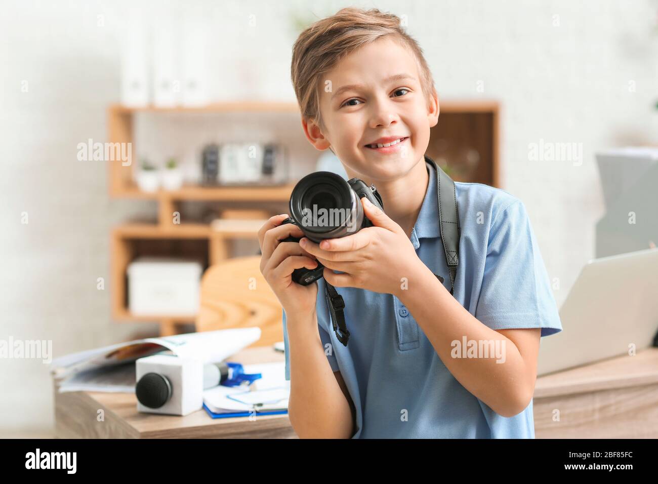 Little journalist with camera in office Stock Photo - Alamy