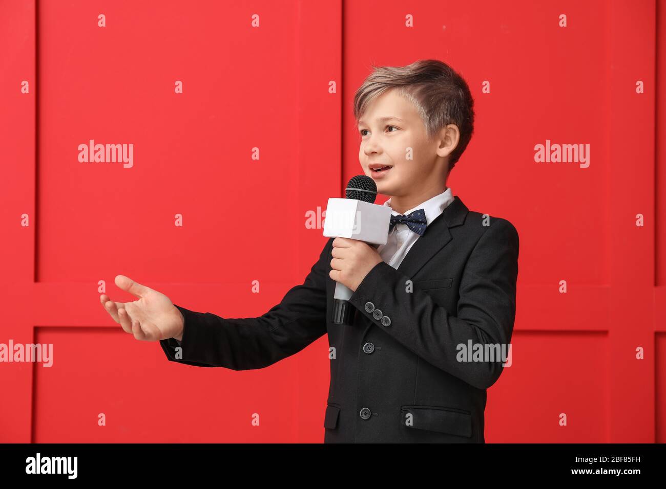 Little journalist with microphone on color background Stock Photo - Alamy