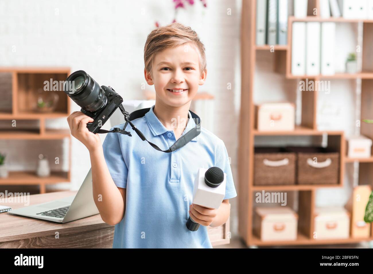 Little journalist with microphone and camera in office Stock Photo - Alamy