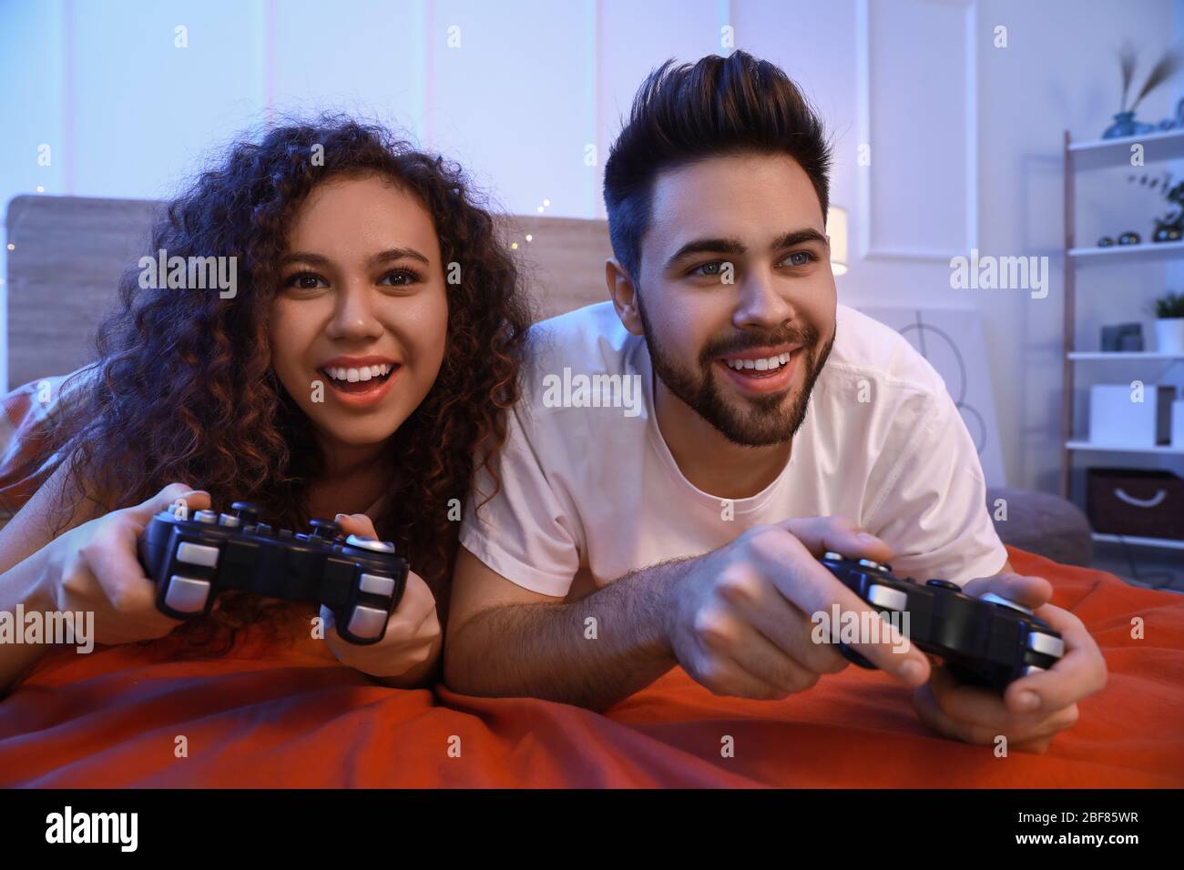 Happy interracial couple playing video hi-res stock photography and ...