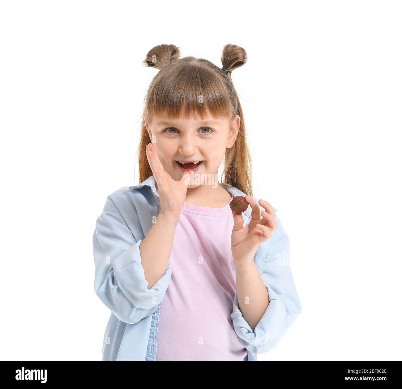 Cute little girl with chocolate candy on white background Stock Photo ...