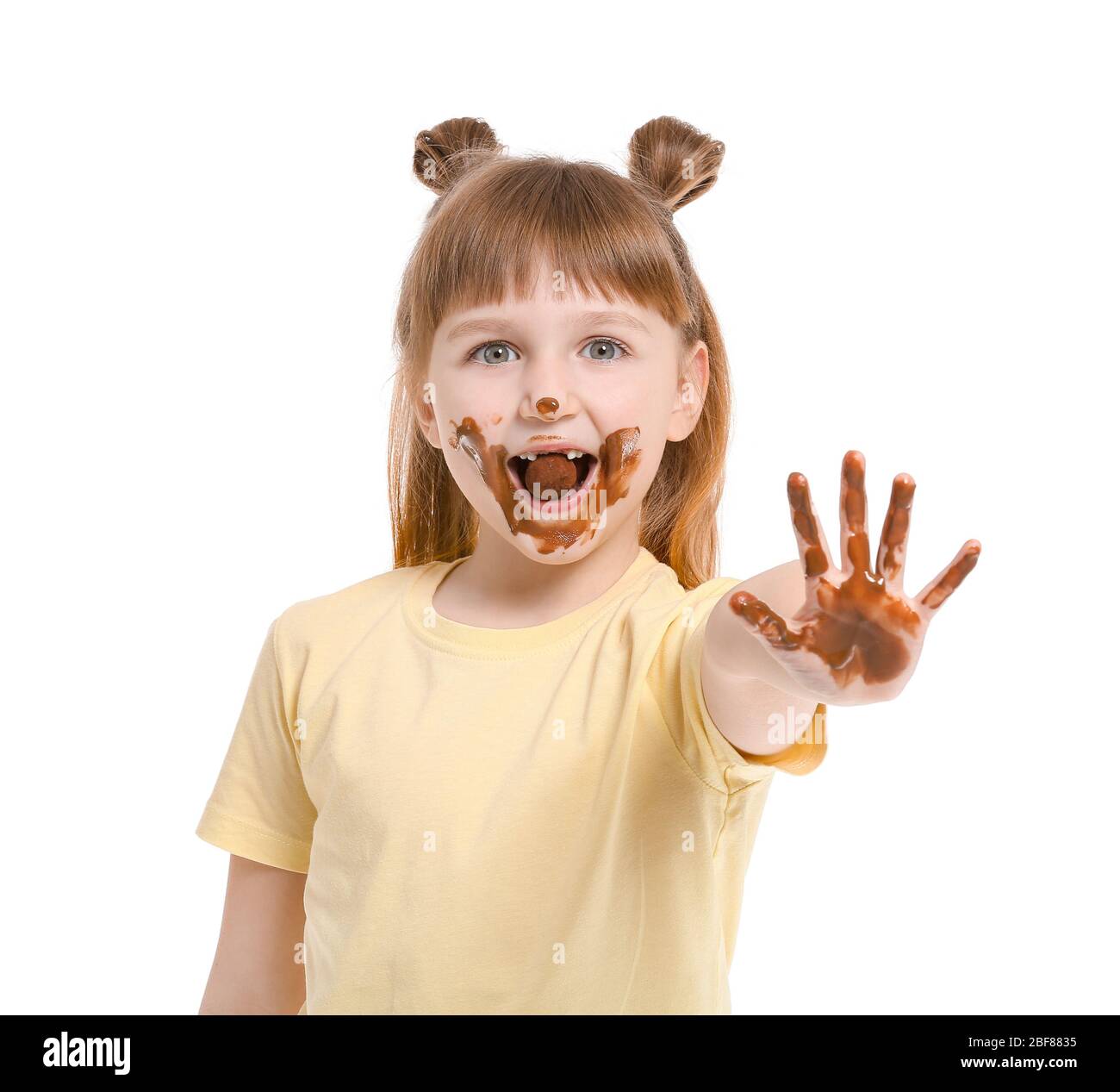 Cute little girl with chocolate on hands and face against white ...