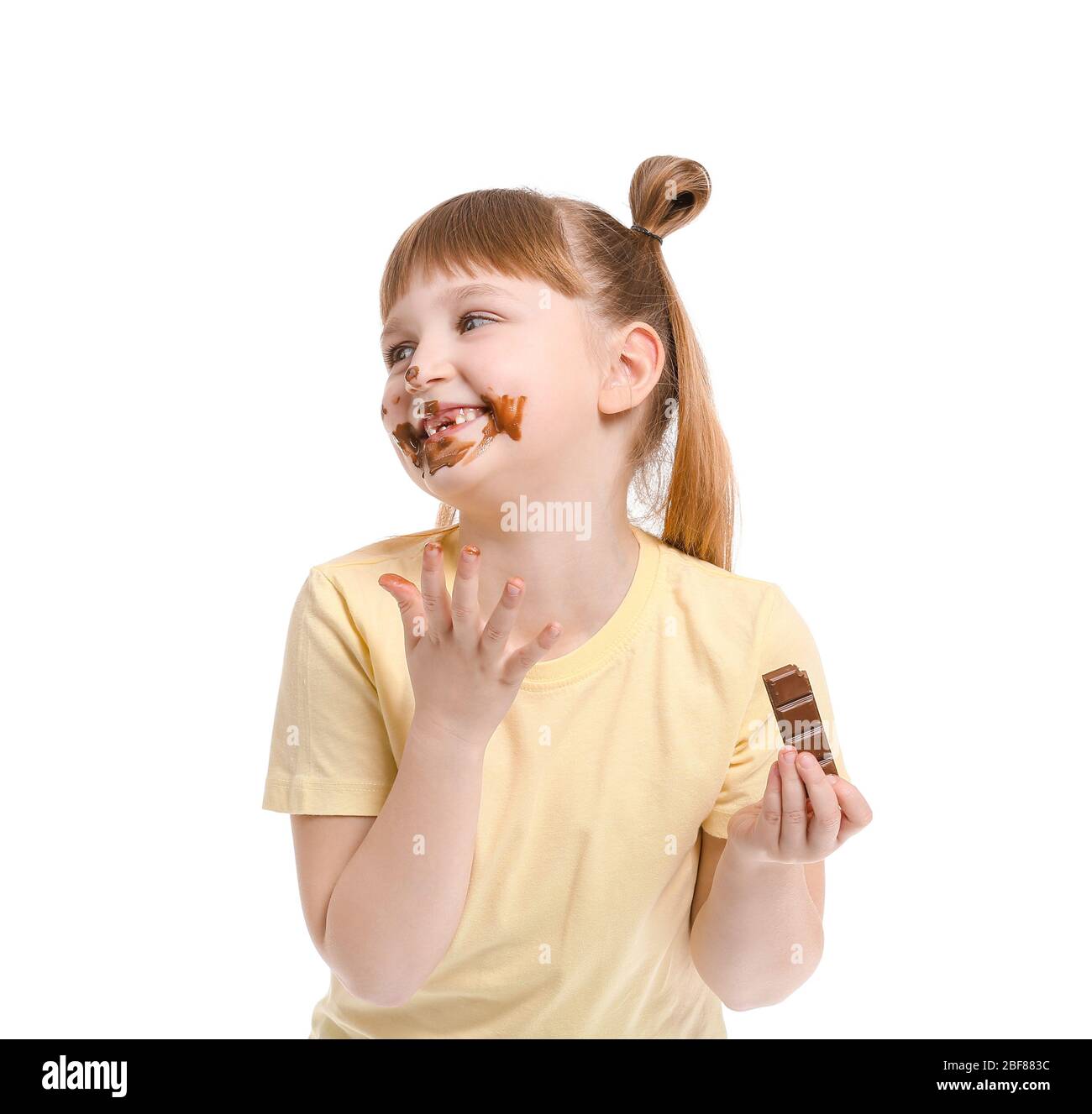 Cute little girl eating chocolate on white background Stock Photo - Alamy