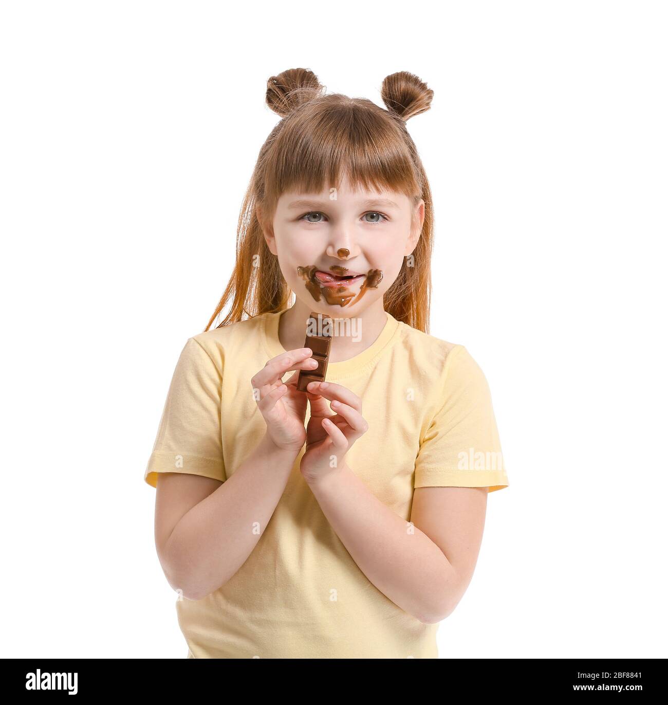 Cute little girl eating chocolate on white background Stock Photo - Alamy