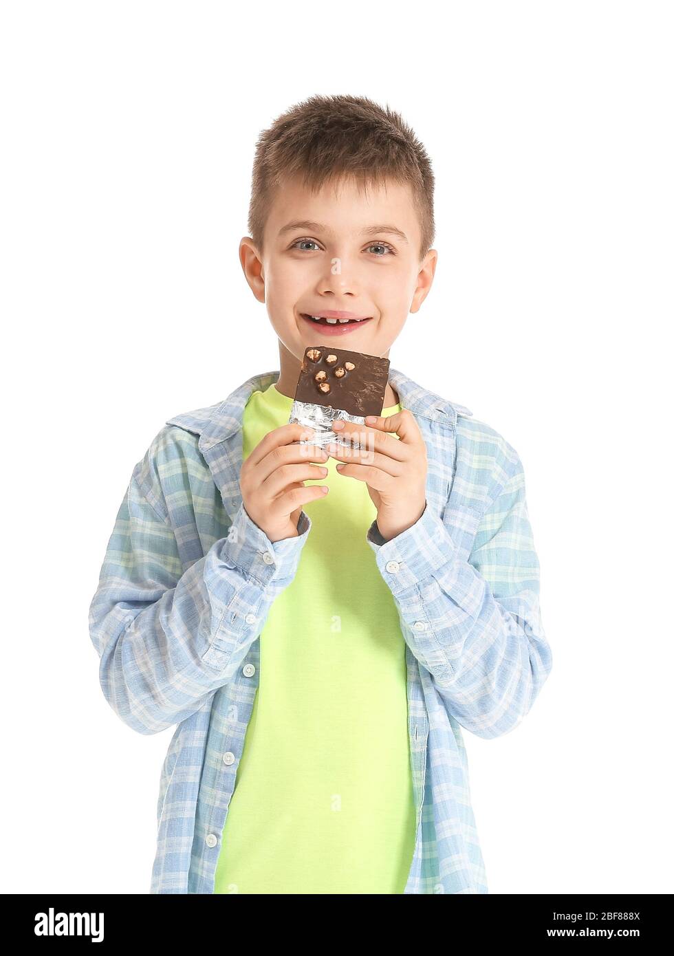Cute little boy eating chocolate on white background Stock Photo - Alamy