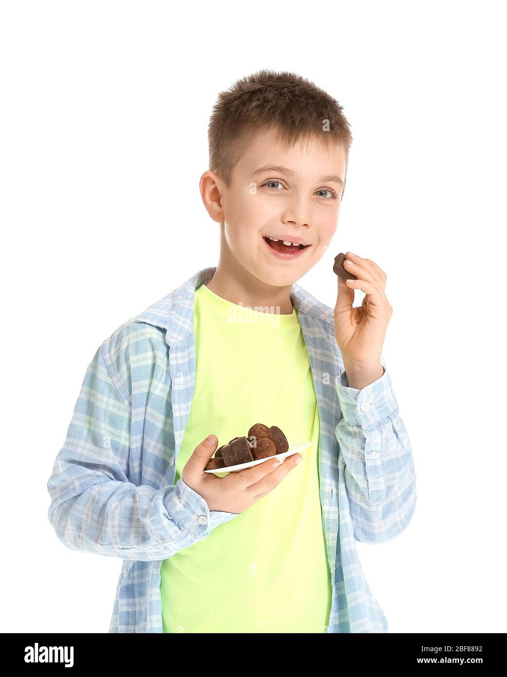 Cute little boy with chocolate candies on white background Stock Photo ...