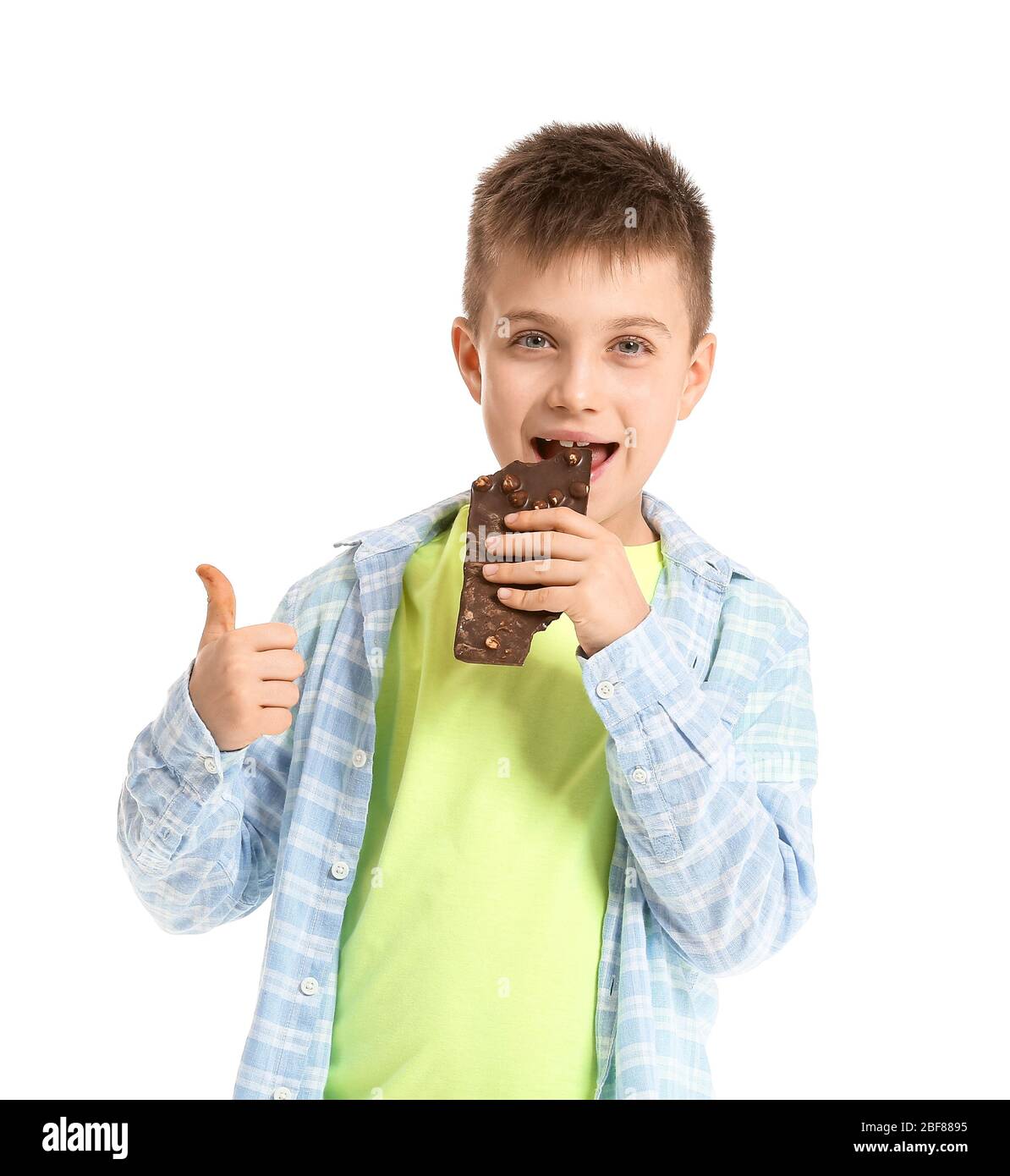 Cute little boy with chocolate showing thumb-up on white background ...