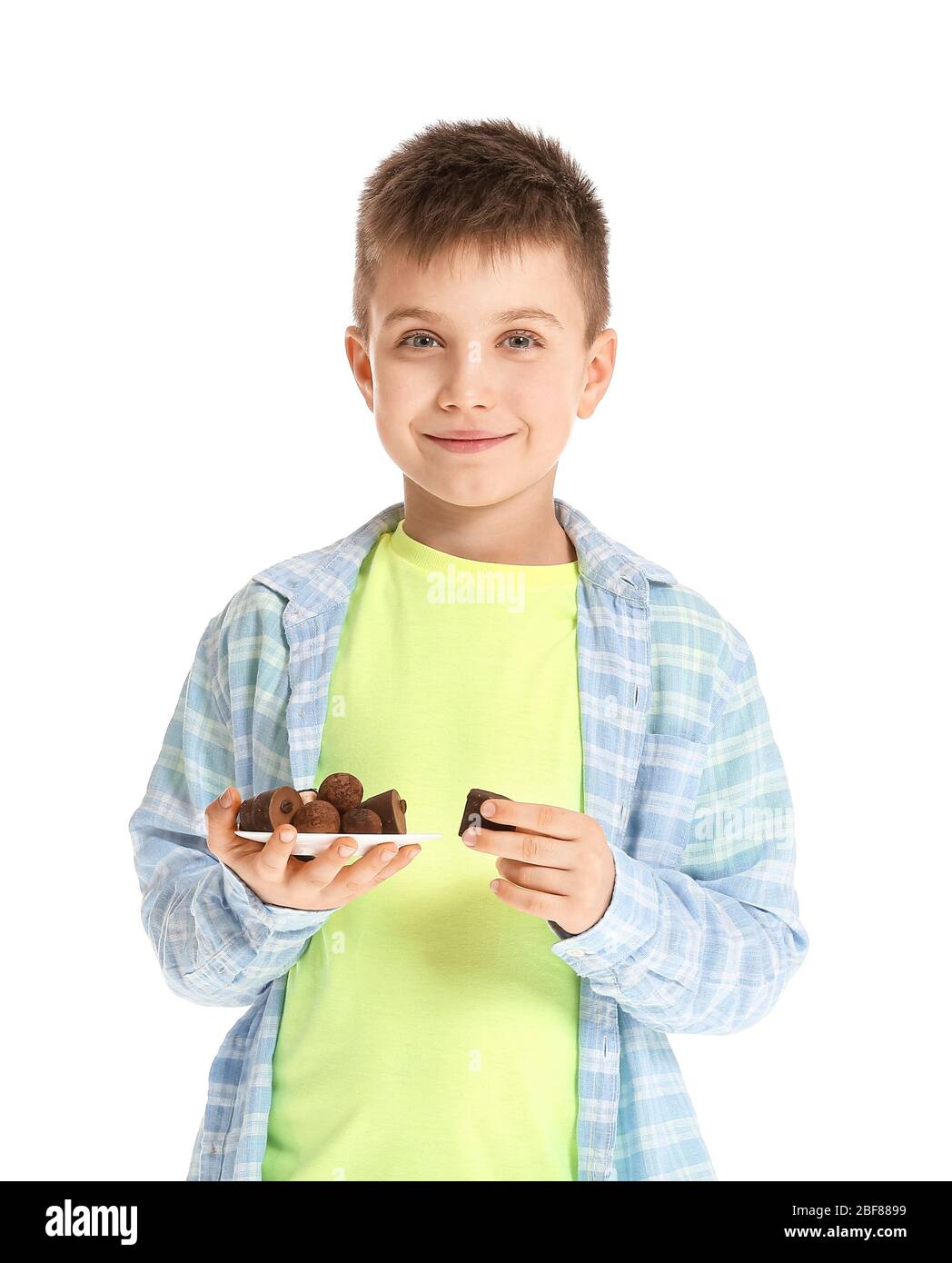 Cute little boy with chocolate candies on white background Stock Photo ...