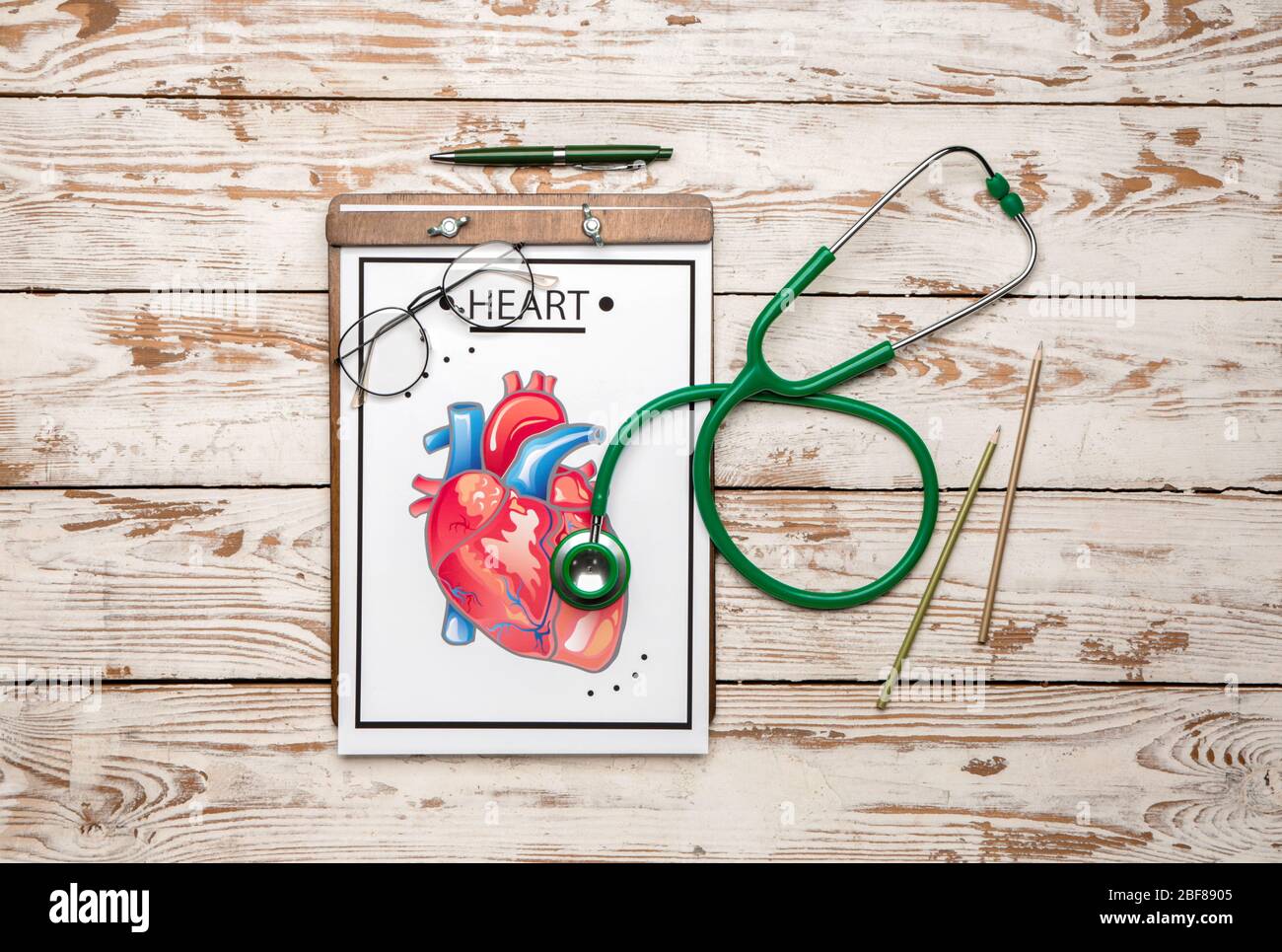 Stethoscope with drawing of human heart on wooden table Stock Photo - Alamy