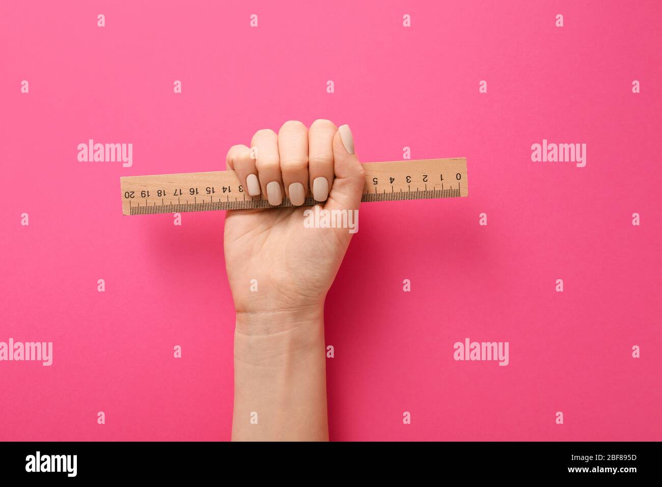 Female hand with ruler on color background Stock Photo - Alamy
