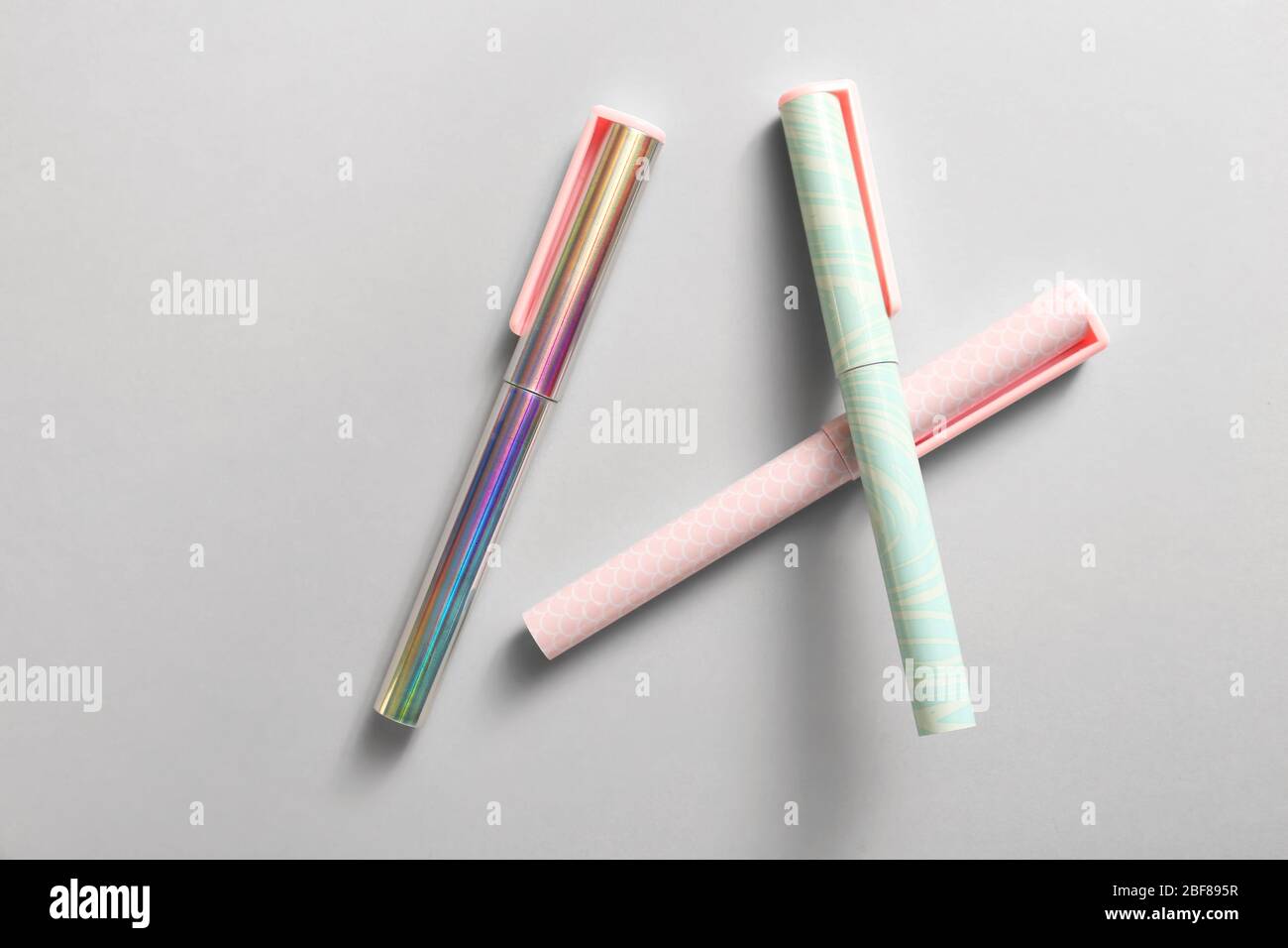 Different pens on grey background Stock Photo - Alamy