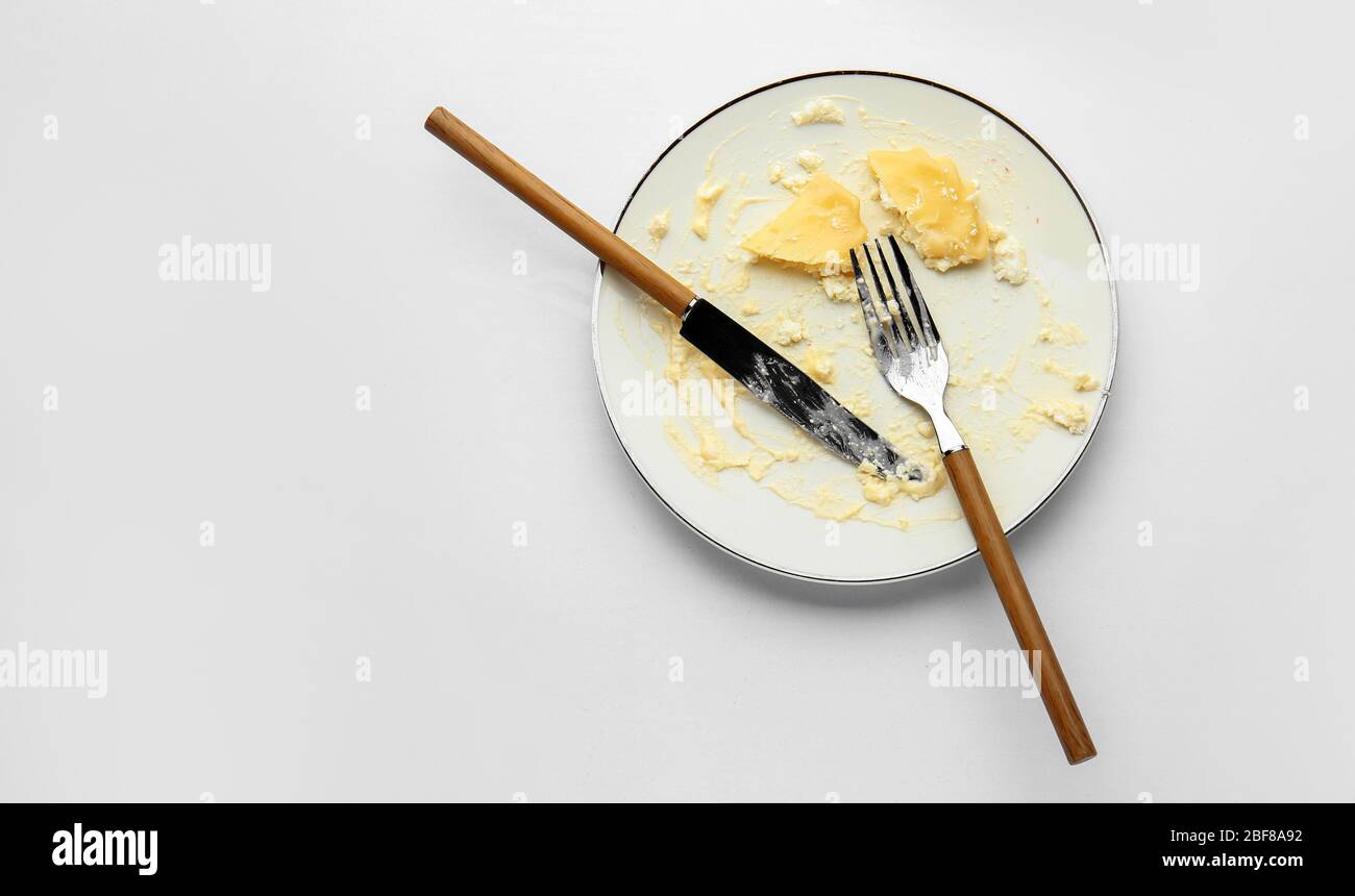 Dirty empty plate with cutlery on white background Stock Photo - Alamy