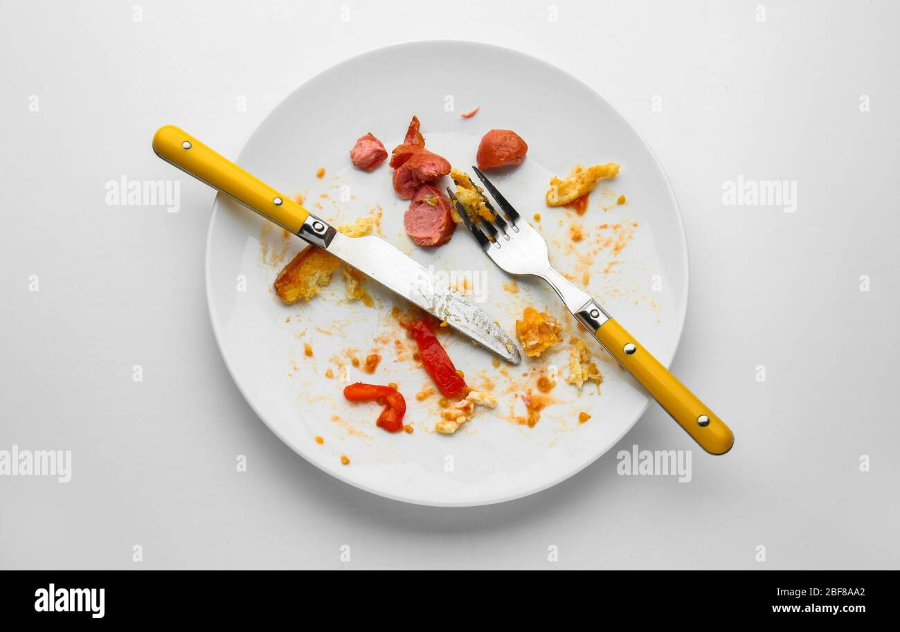 Dirty empty plate with cutlery on white background Stock Photo - Alamy
