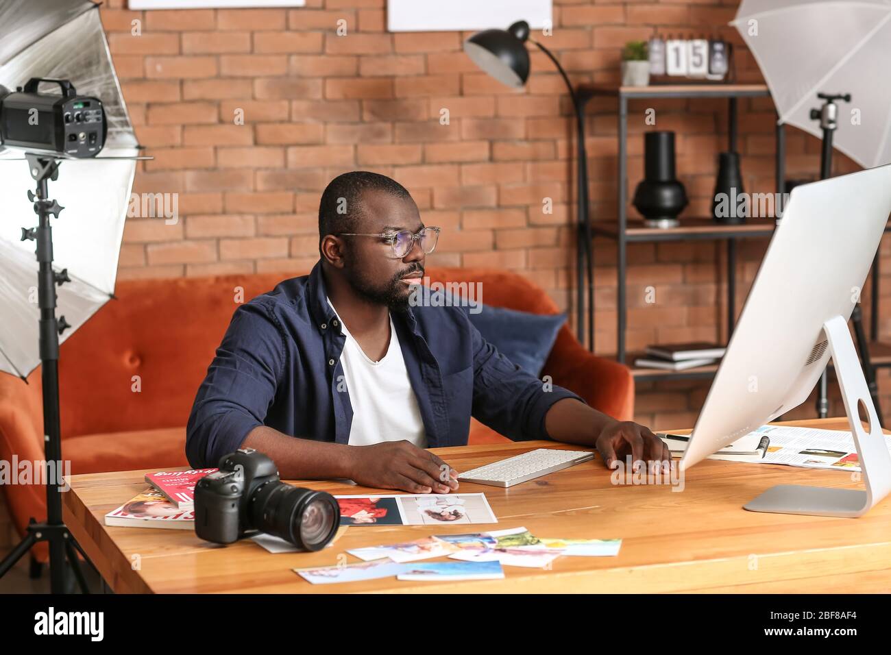 African-American photographer at table in studio Stock Photo - Alamy