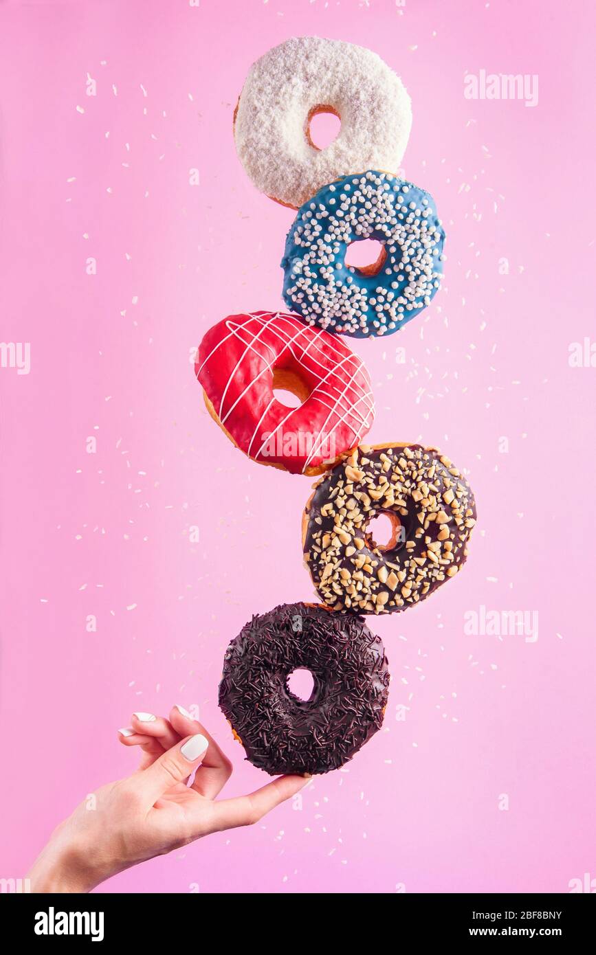 Balancing donuts on the tip of the woman's finger. Multicolored ...