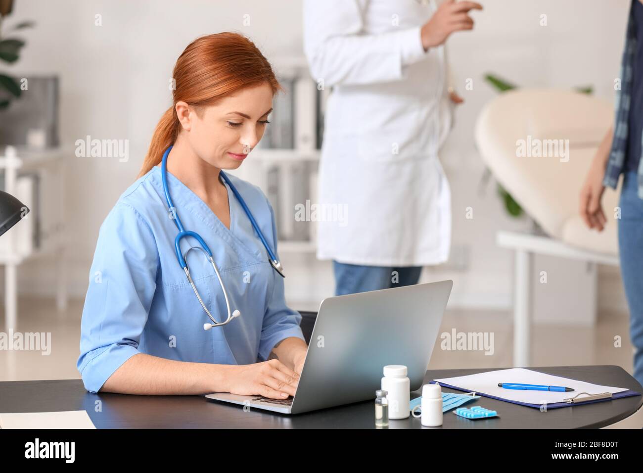 Female medical assistant working in clinic Stock Photo - Alamy