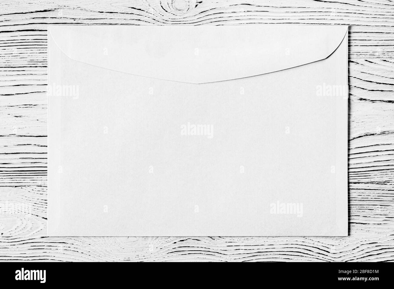 White postal envelope on a wooden table. Abstract background for design ...