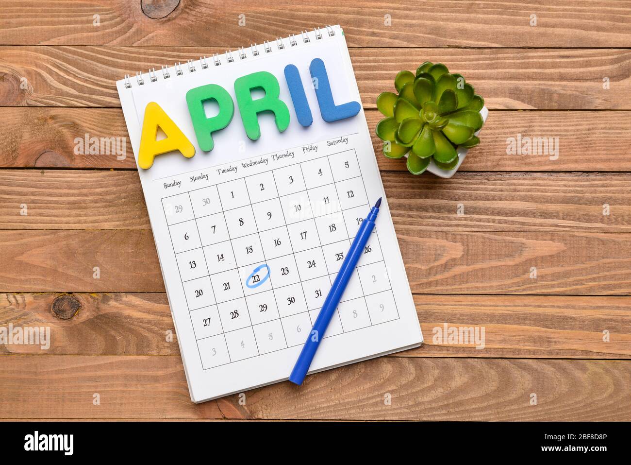 Calendar with marked date of Earth Day on wooden background Stock Photo ...