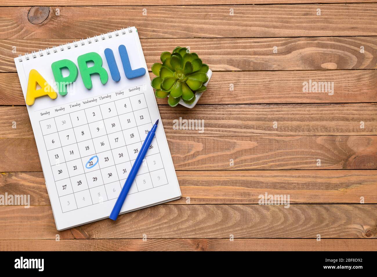 Calendar with marked date of Earth Day on wooden background Stock Photo ...