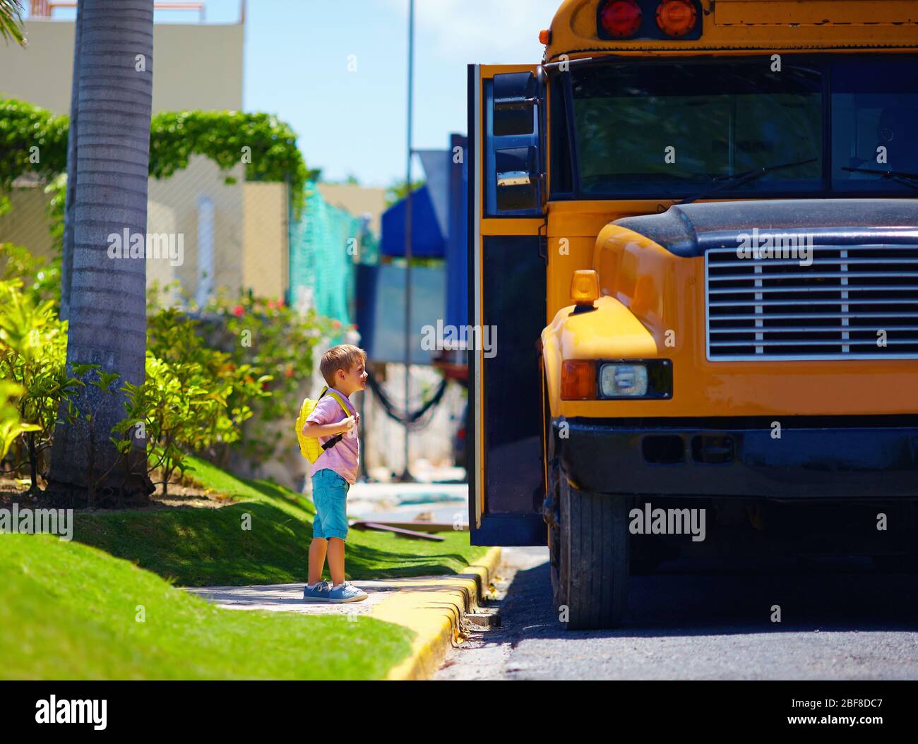 young boy, kid getting on the school bus, ready to go to school Stock ...
